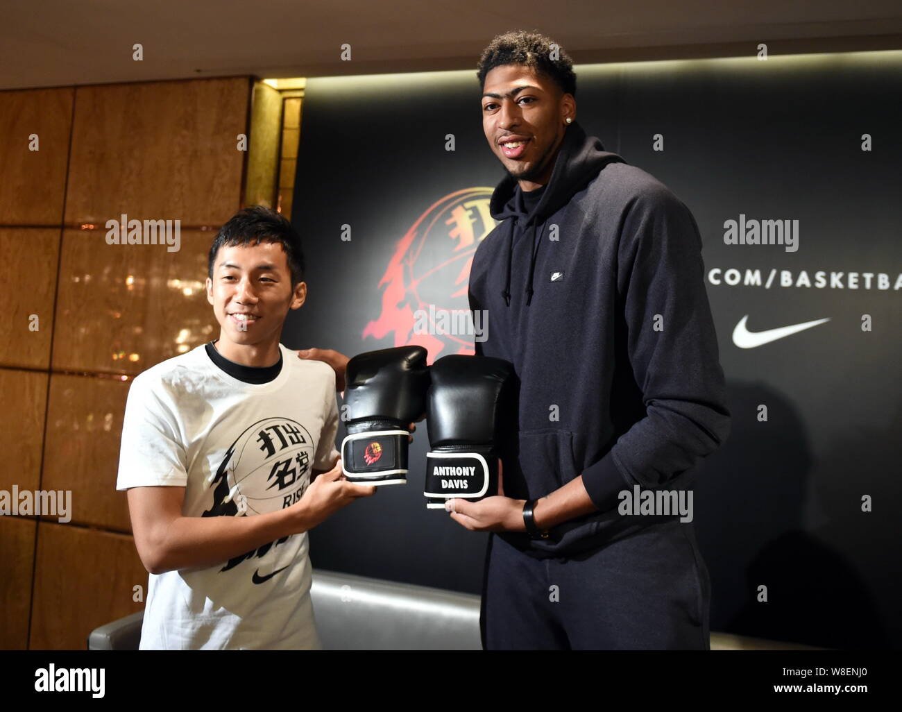 NBA star Anthony Davis, right, receives a pair of boxing gloves as gift ...