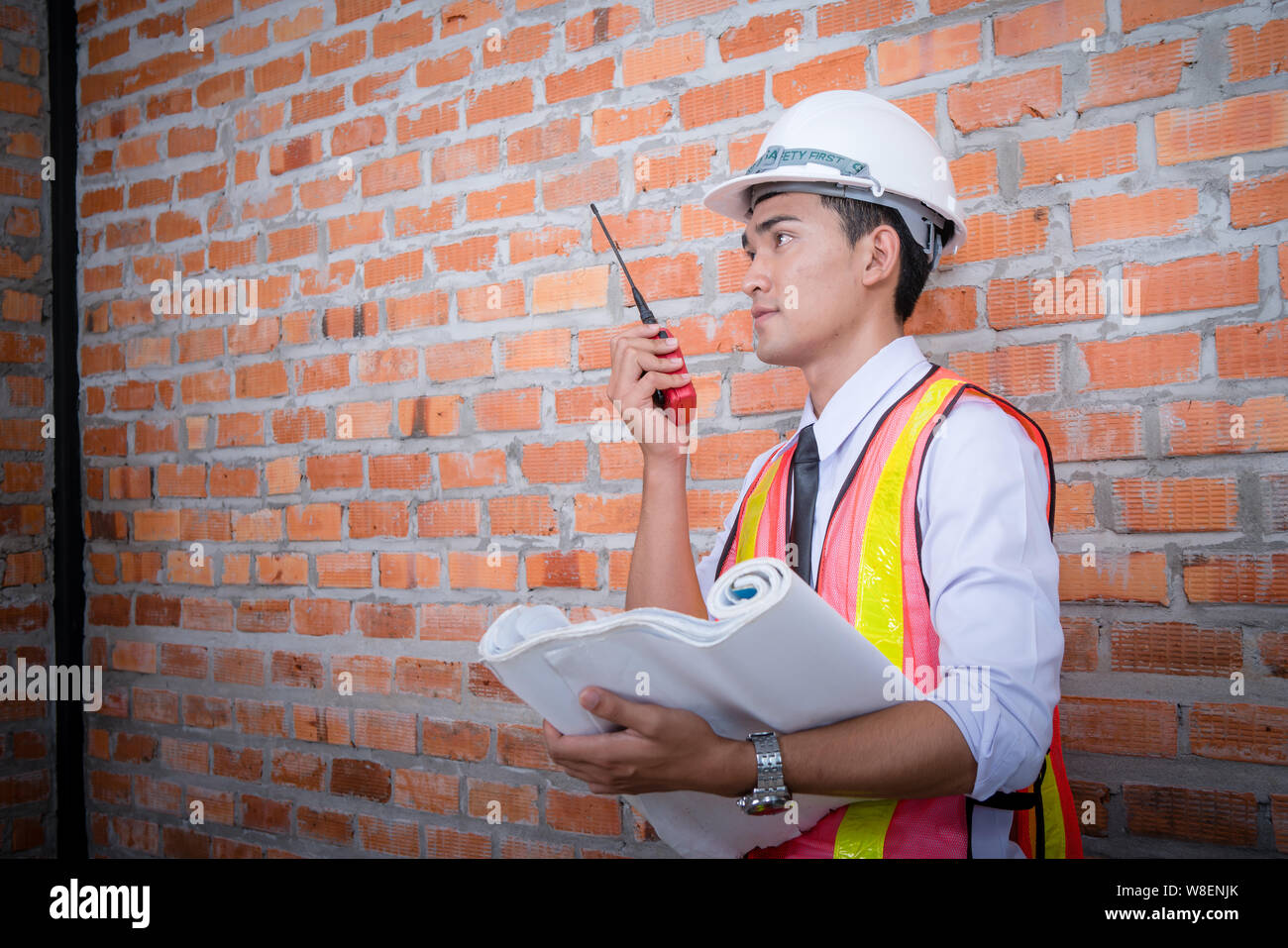 Asian engineer man with blueprints with brick wall background Stock ...