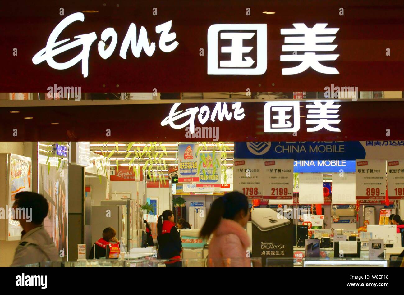 --FILE--Customers walk past a Gome home appliances store at a shopping ...
