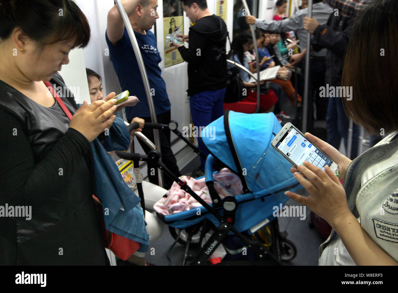 --FILE--Passengers use their smartphones to surf the Internet in a ...