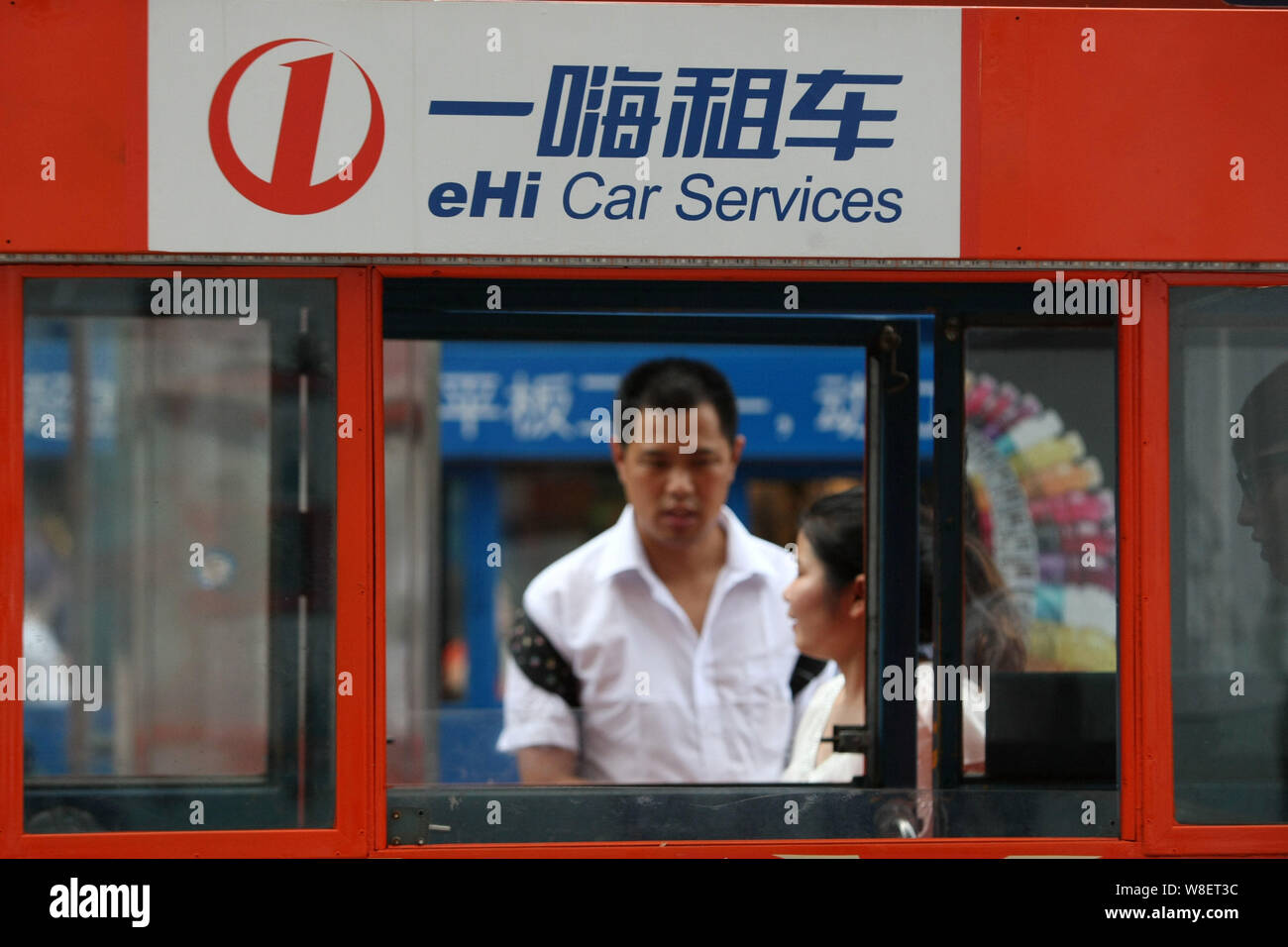 --FILE--Pedestrians walk past a sightseeing car with an advertisement ...