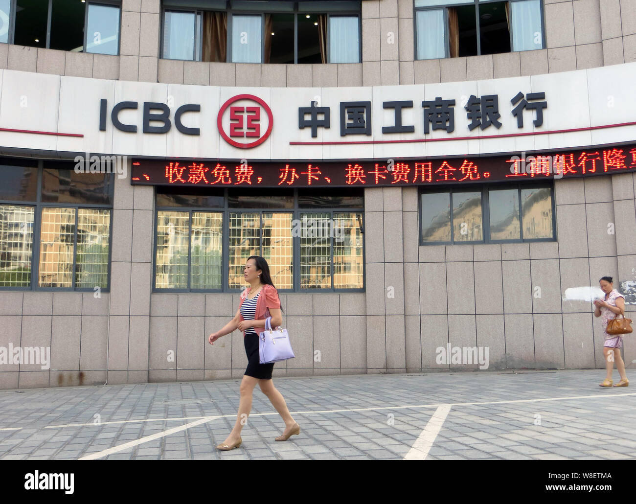 Pedestrians walk past a branch of ICBC (Industrial and Commercial Bank ...