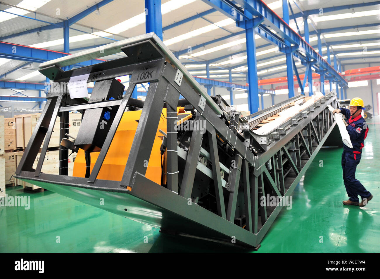 --FILE--A Chinese worker assembles parts of escalators at a factory in ...