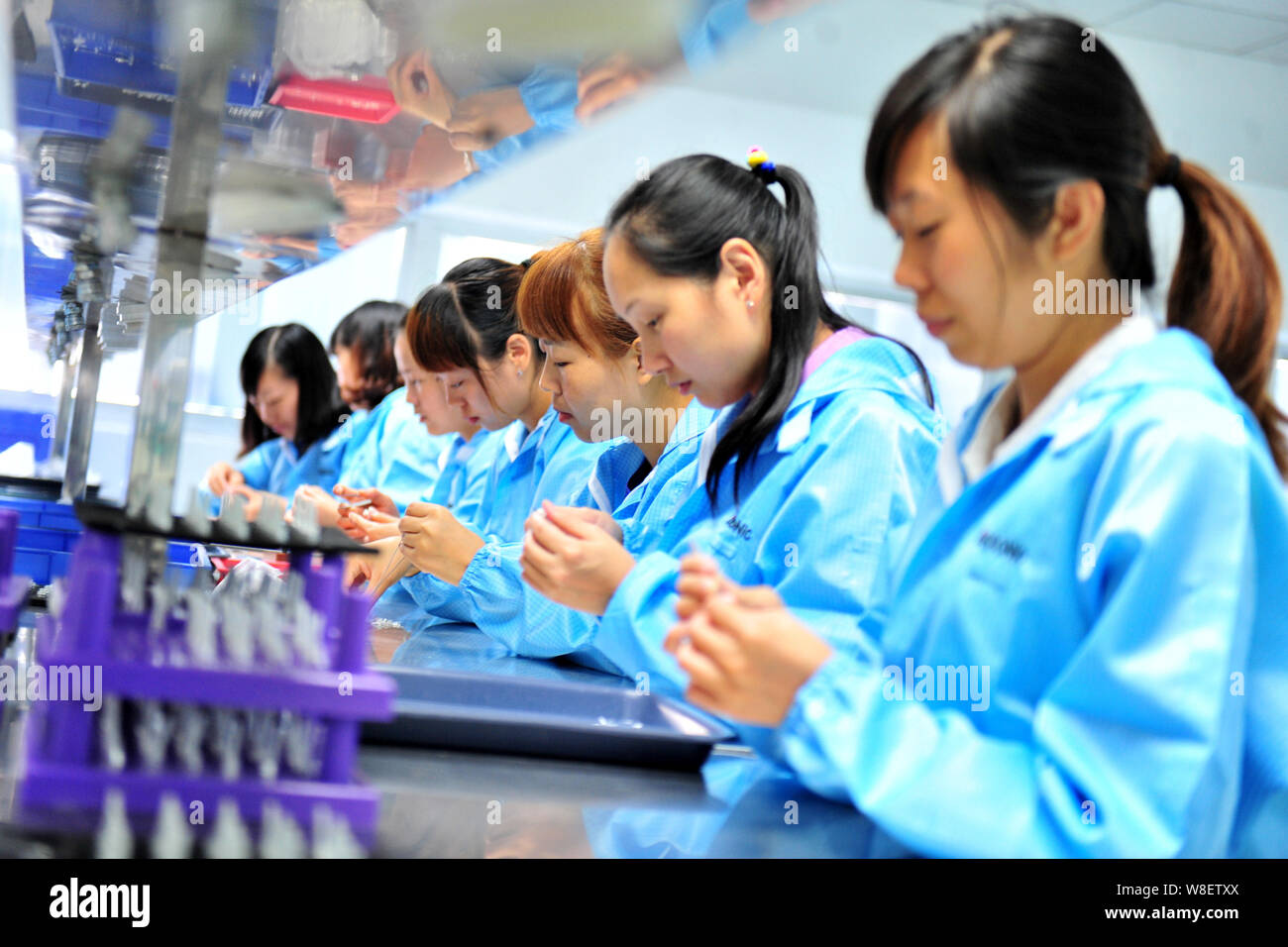 --FILE--Female Chinese workers produce electric products at a factory ...