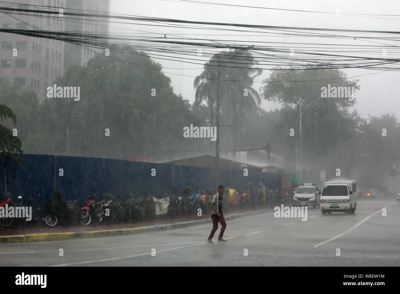 Quezon City, Philippines. 9th Aug, 2019. A man walks in the strong ...