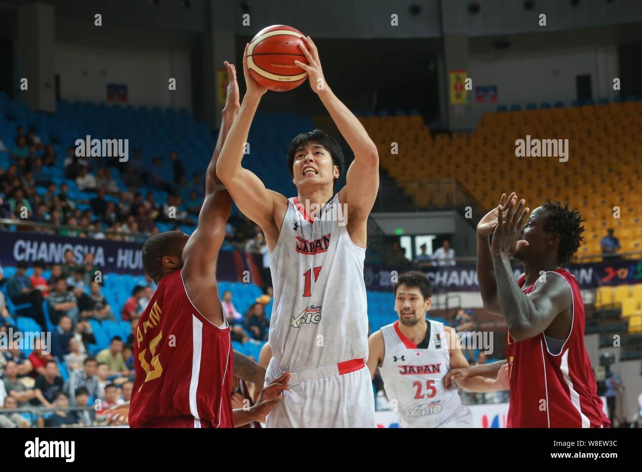 Joji Takeuchi of Japan, center, drives to the basket against players of ...