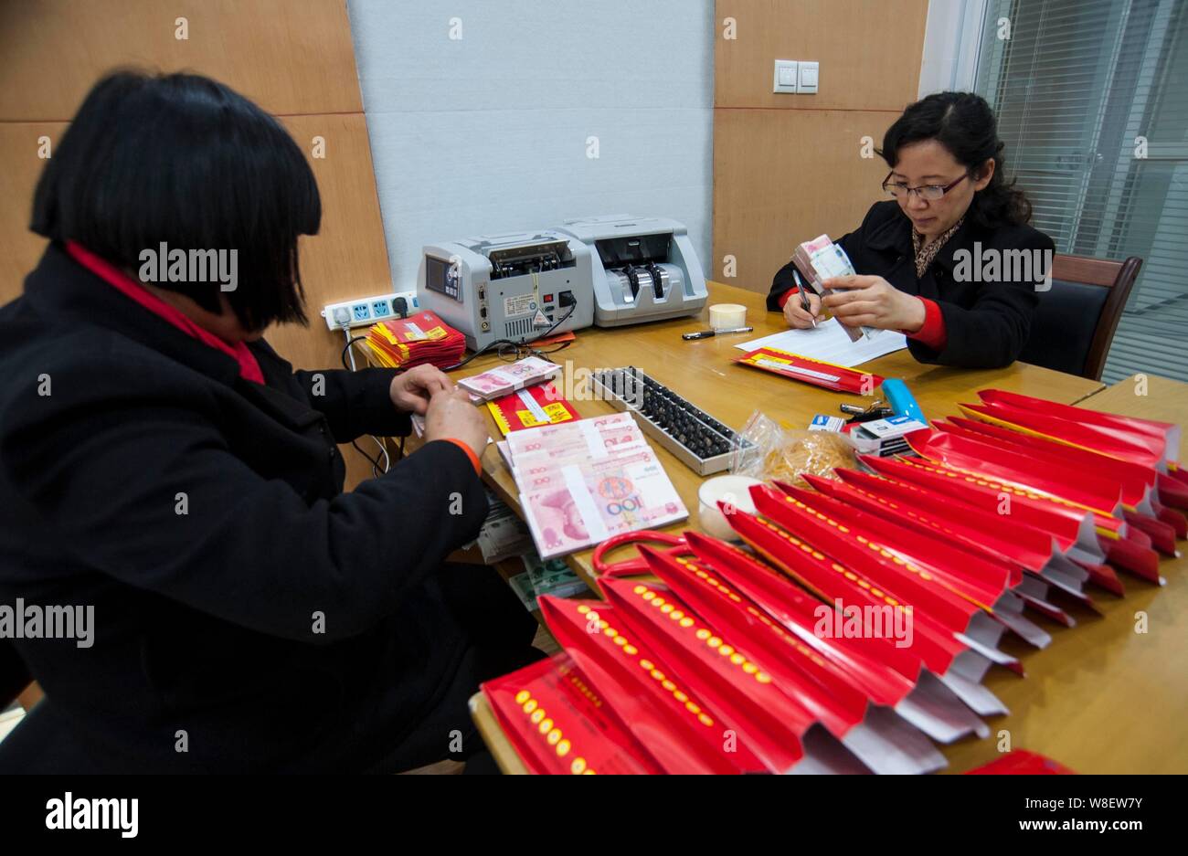 --FILE--Chinese clerks count RMB (renminbi) yuan banknotes at a branch ...