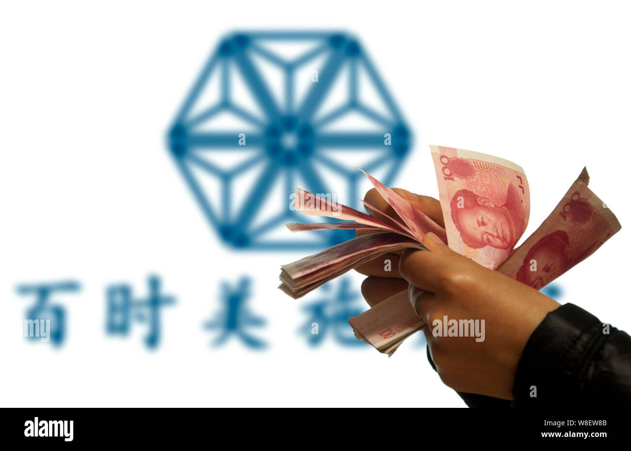 --FILE--A Chinese man counts RMB (renminbi) yuan banknotes in front of ...