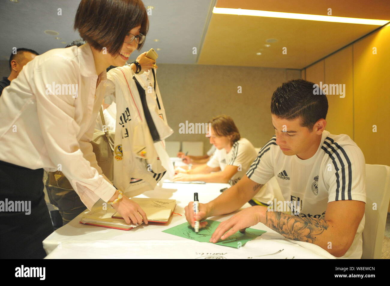 James Rodriguez of Real Madrid, right, signs an autograph for a fan at ...