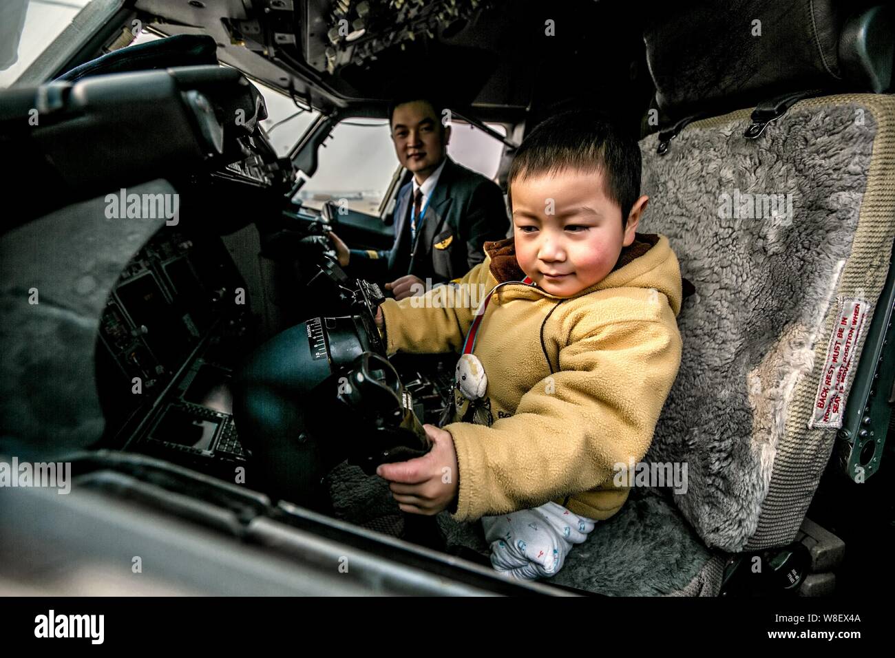 The four-year-old legless boy Xiao Feng, front, poses with a pilot of ...