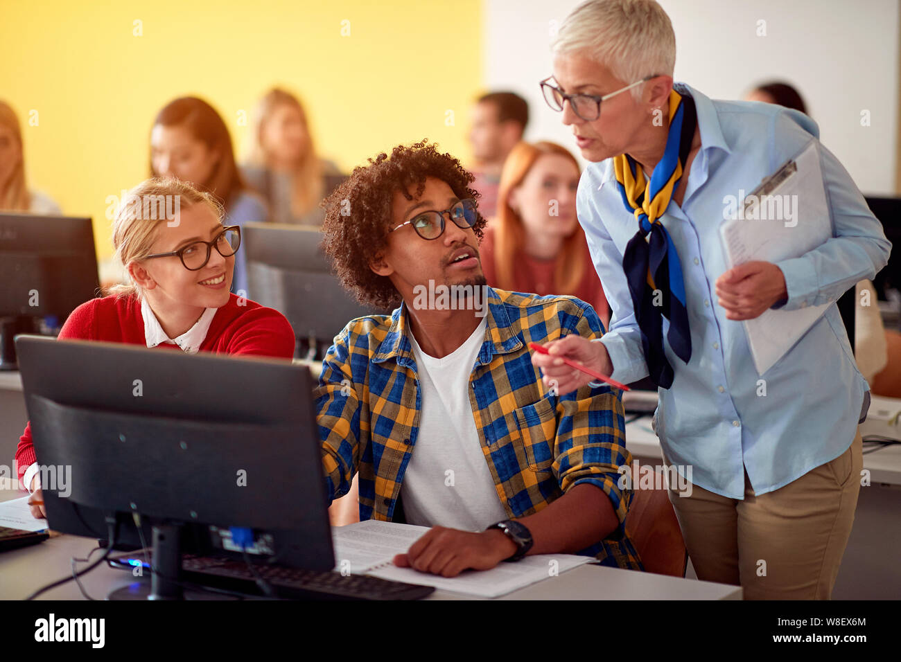 lecturer in computer class assisting student on university campus Stock ...