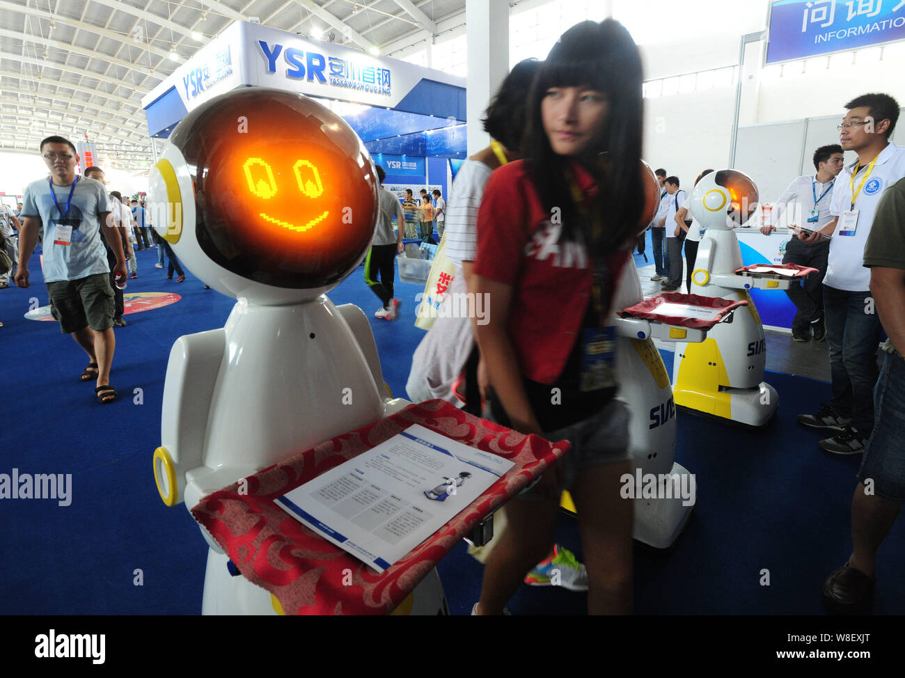 Visitors look at food delivery robots of Siasun during the 14th China ...