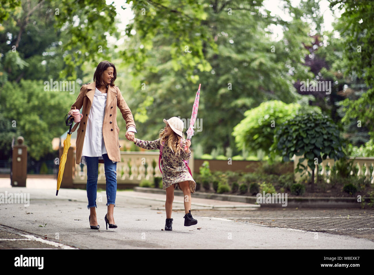 Back to school. Happy business mother and daugther go to elementary ...