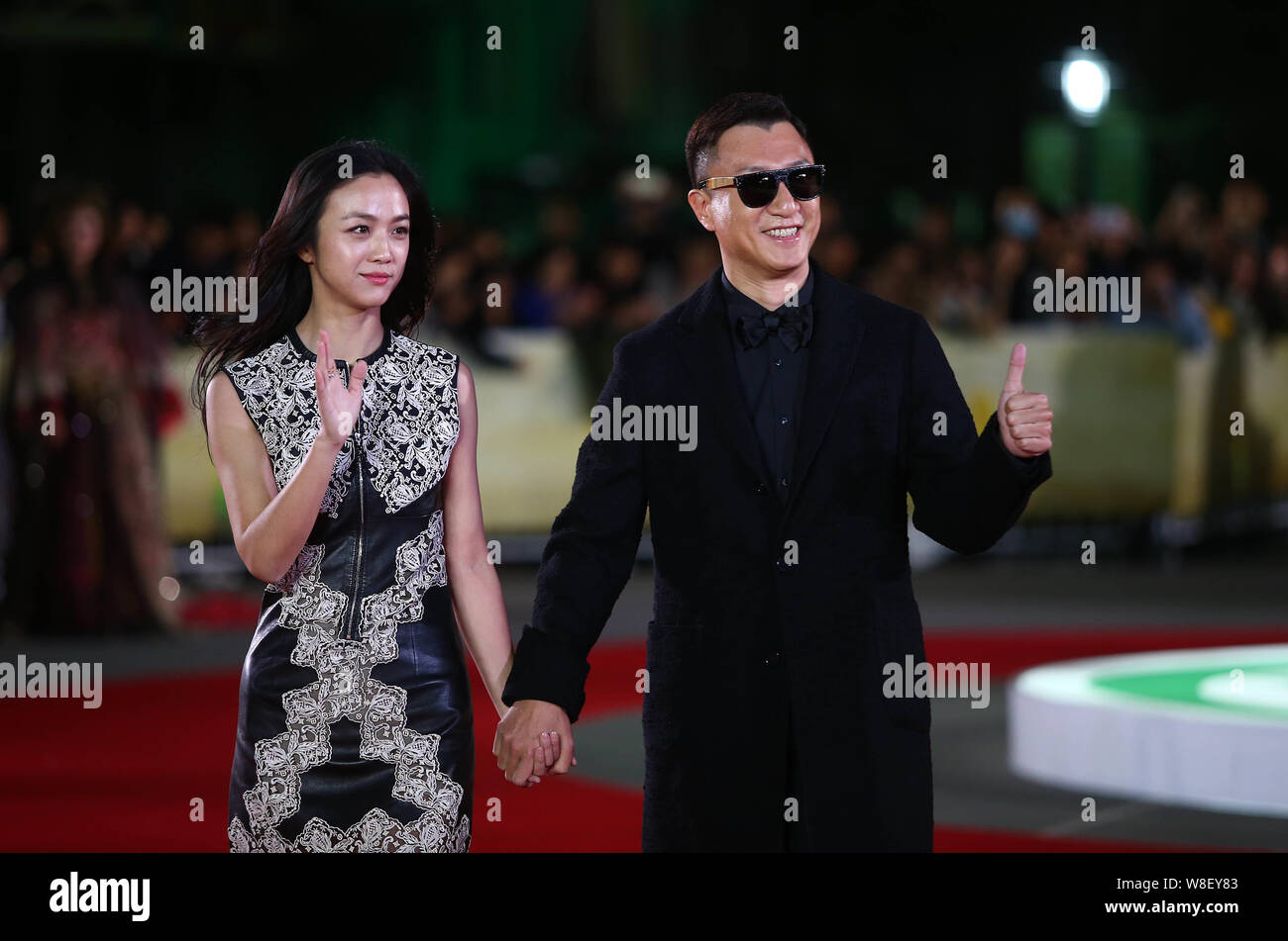 Chinese actress Tang Wei, left, and actor Sun Honglei wave as they ...
