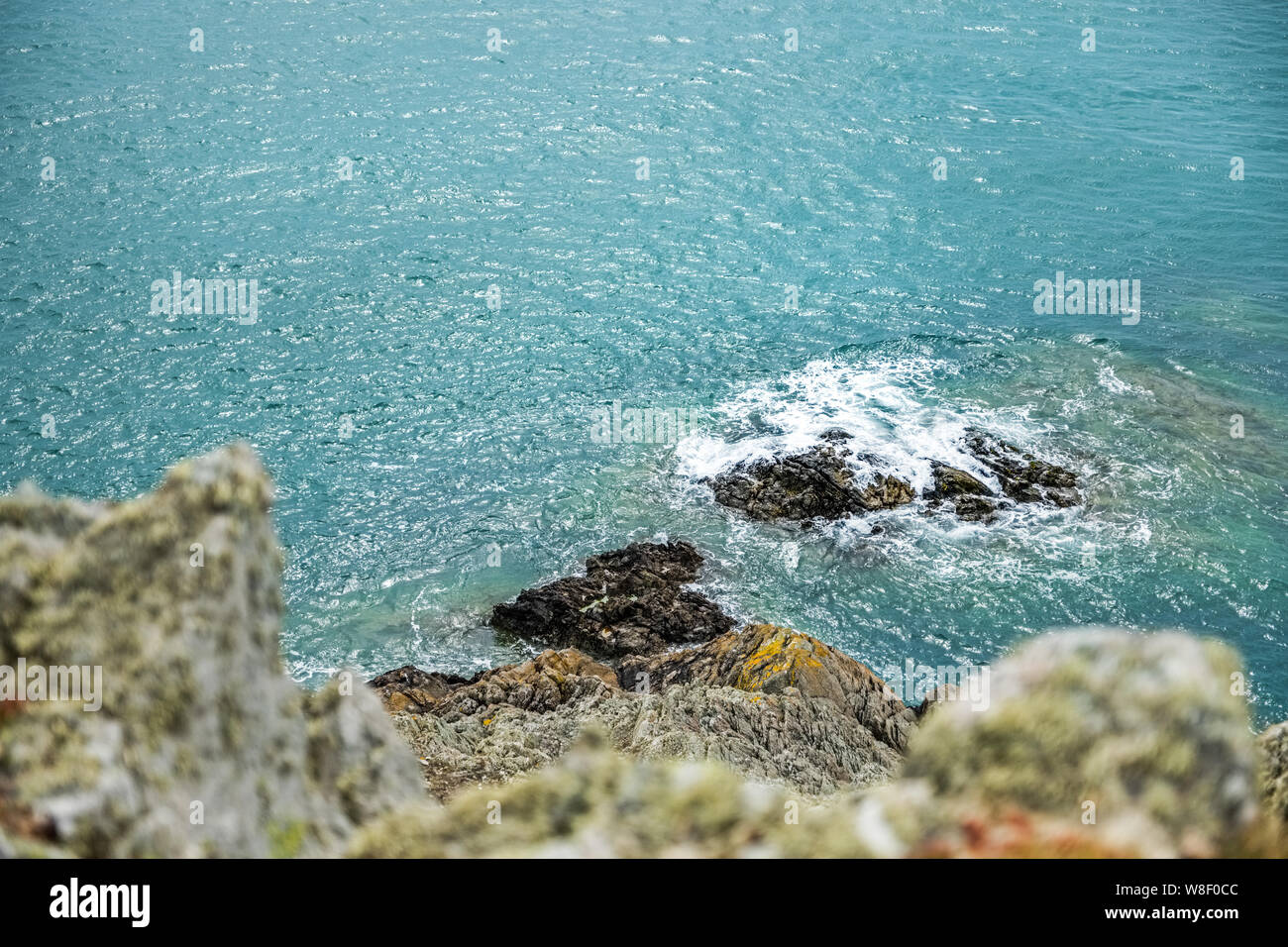 The sea washing over rocks below cliffs on the Welsh coast Stock Photo ...