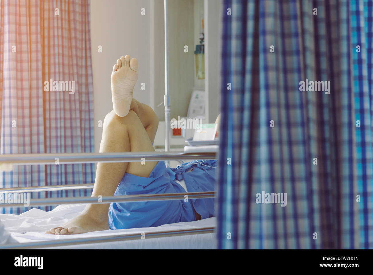Elderly male patient relaxing on bed with his legs crossed in a good ...