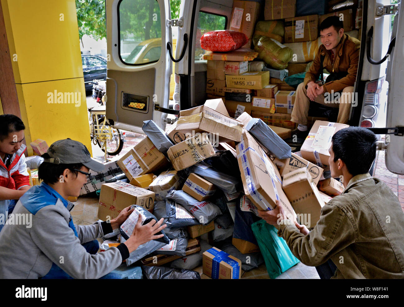 --FILE--Chinese workers try to load an overcrowded van with more ...