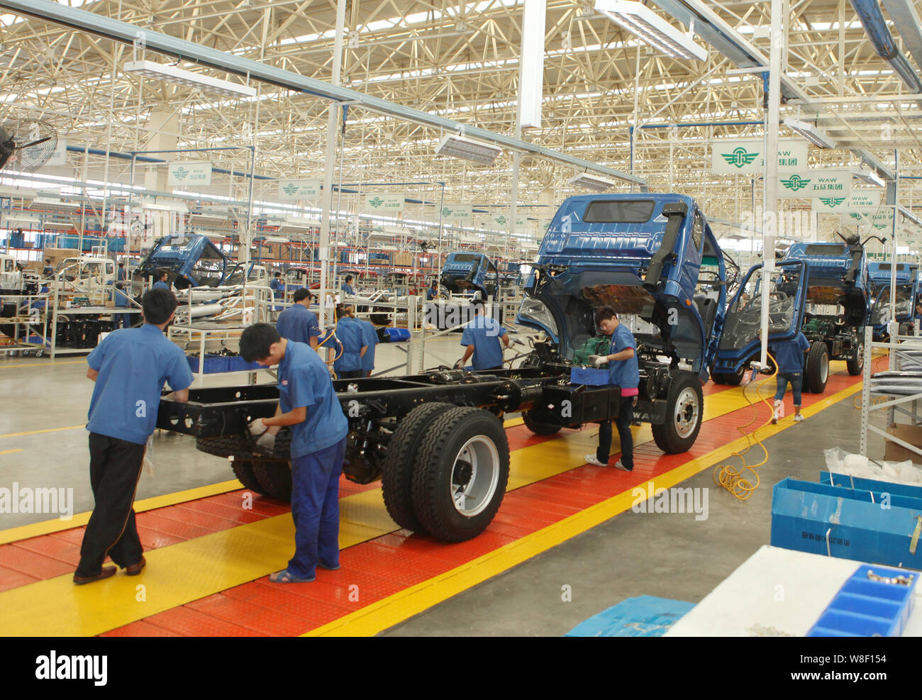 Chinese workers assemble trucks on the assembly line at a truck plant ...
