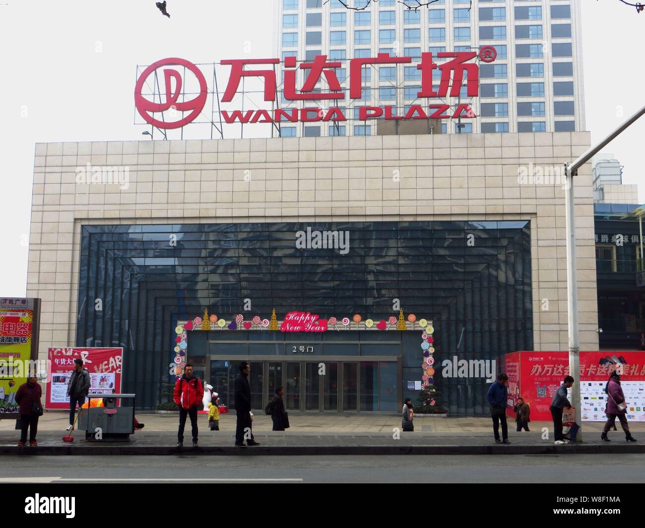 --FILE--Pedestrians stand in front of a Wanda Plaza of Wanda Group in ...