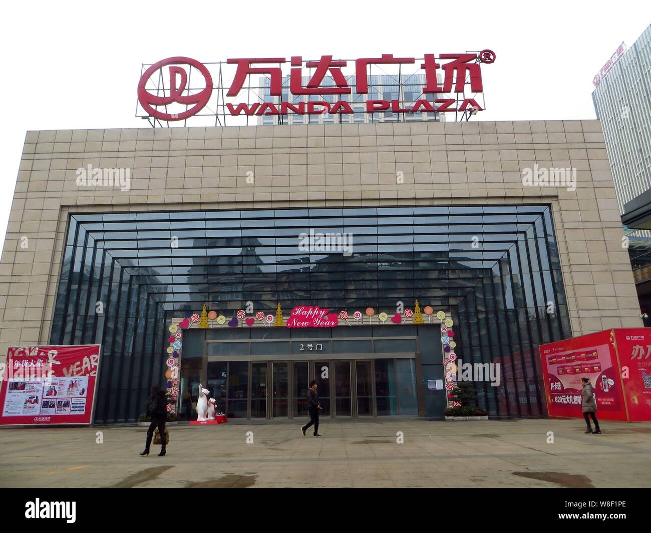 --FILE--Pedestrians walk past a Wanda Plaza of Dalian Wanda Group in ...