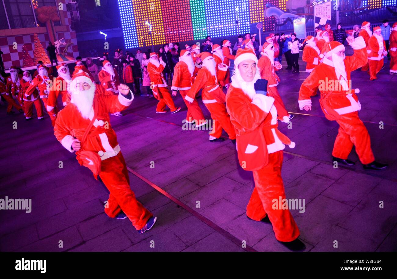 Entertainers dressed in Santa Claus costumes perform in a flash mob to ...
