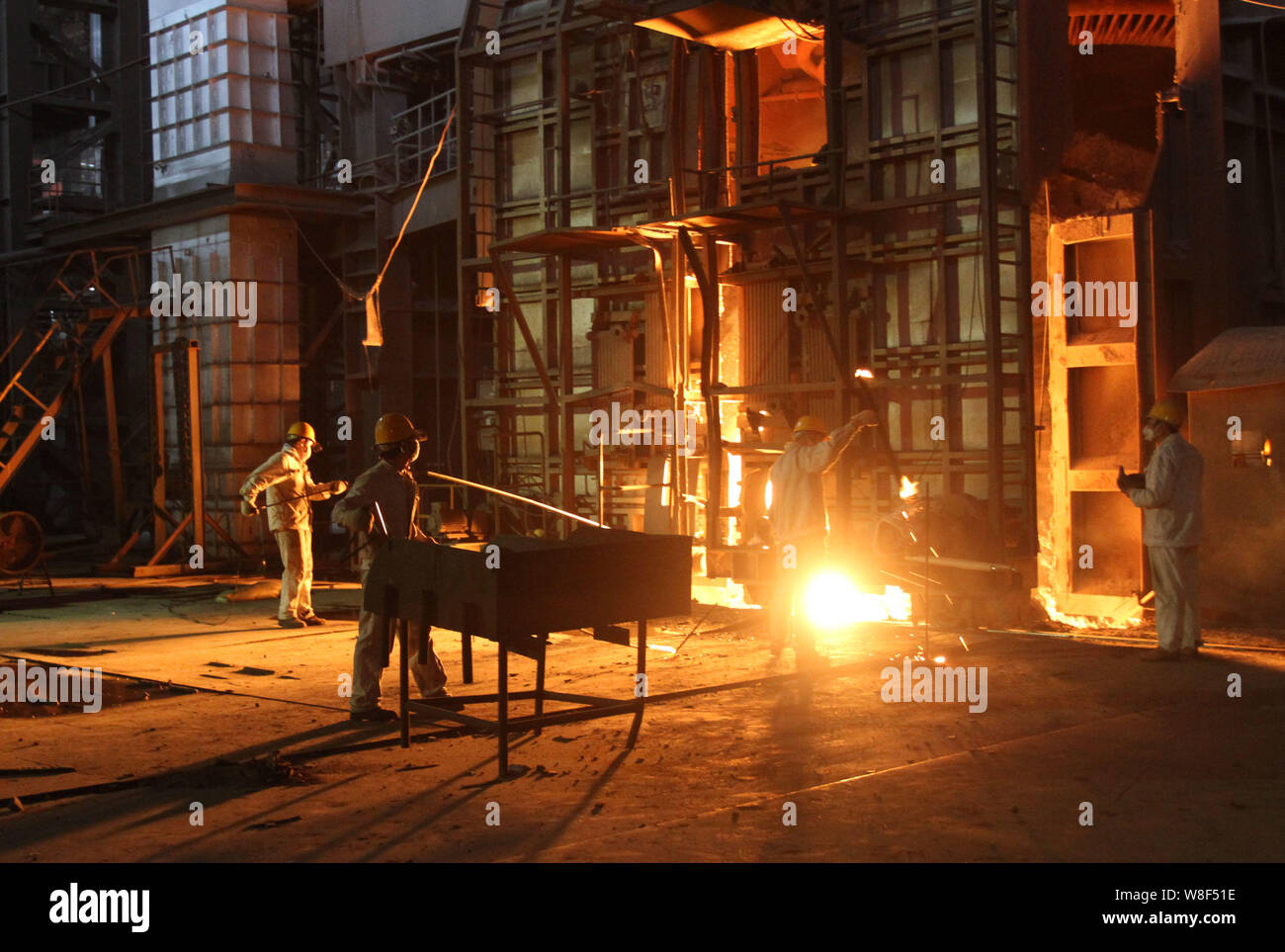 --FILE--Chinese workers survey the production of steel at a steel plant ...