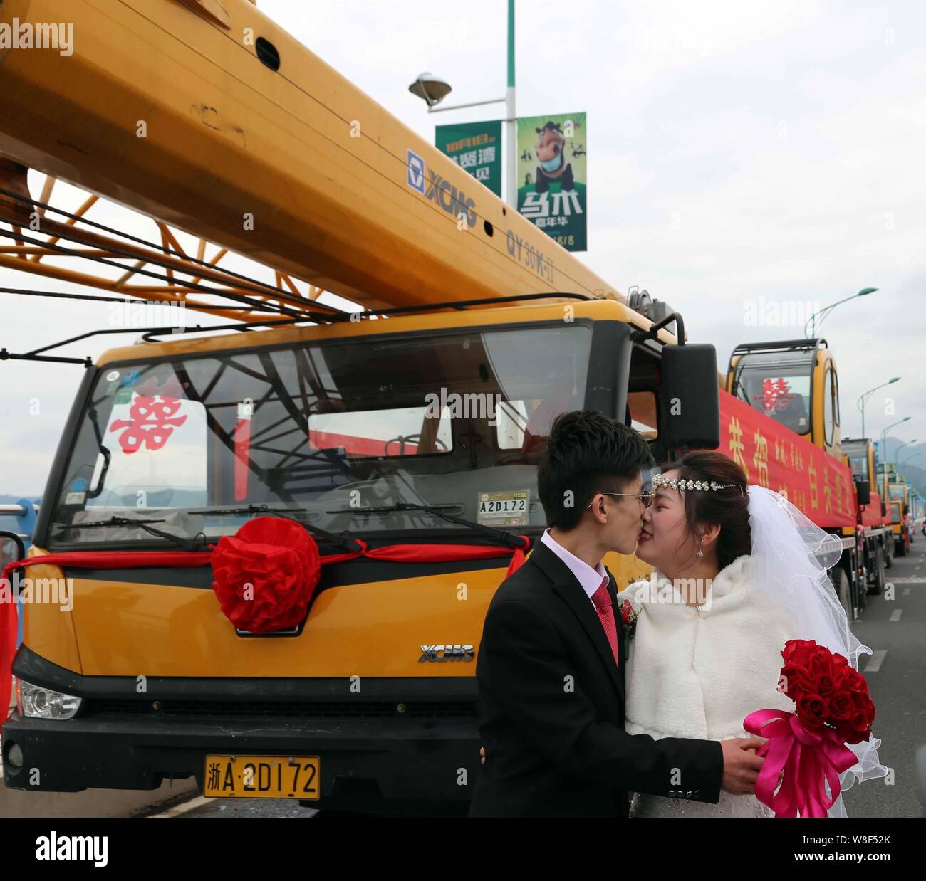 Chinese groom Xie Jiangjian, left, kisses his bride in front of a ...
