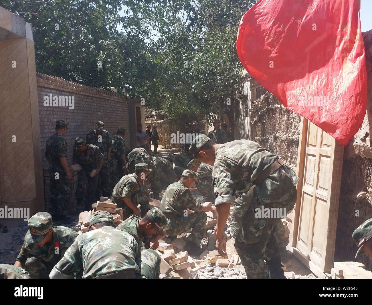 Chinese rescuers clear away debris of a devastated house after a 6.5 ...