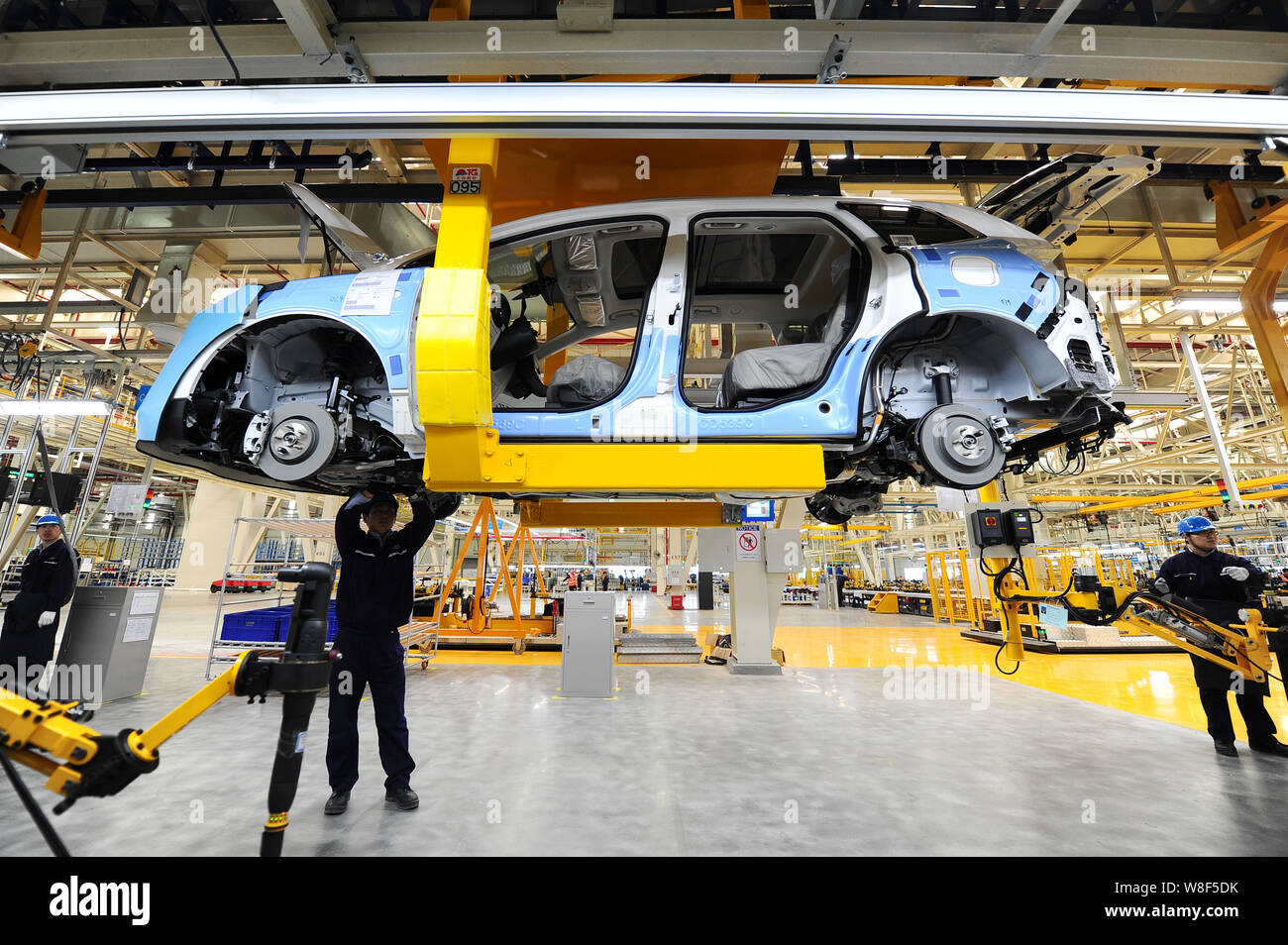 A Chinese worker assembles a Ford SUV on the assembly line at the auto ...