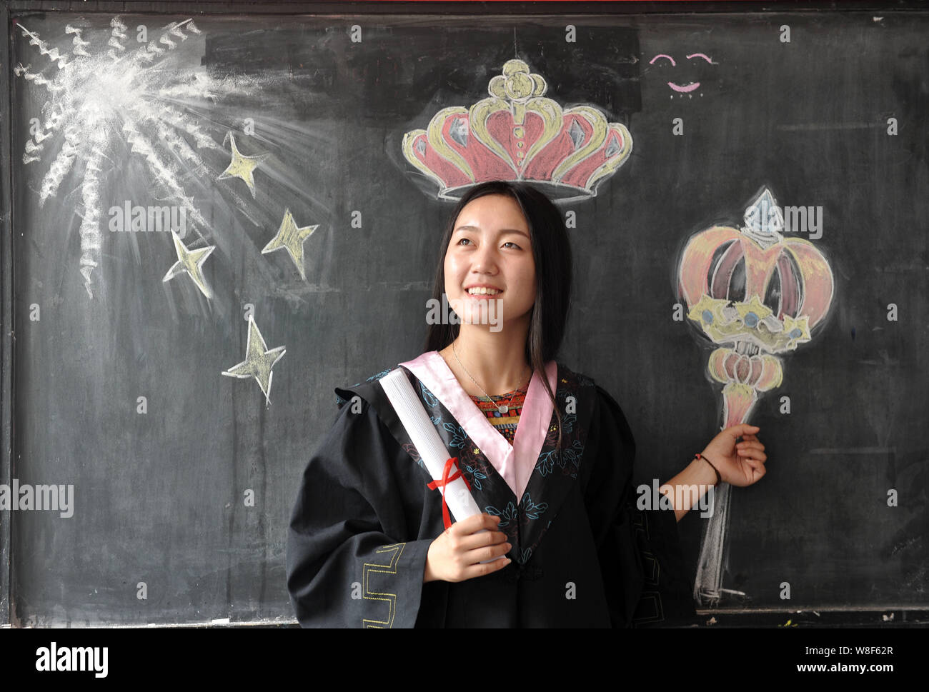 A Chinese graduates dressed in an academic gown poses for graduation ...