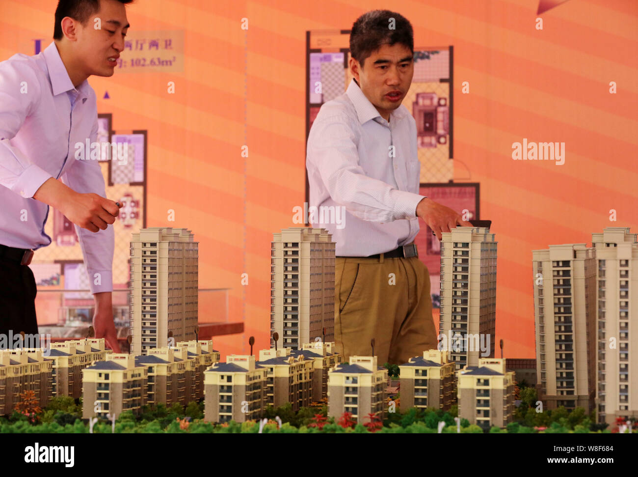 --FILE--A Chinese employee introduces models of residential apartment ...
