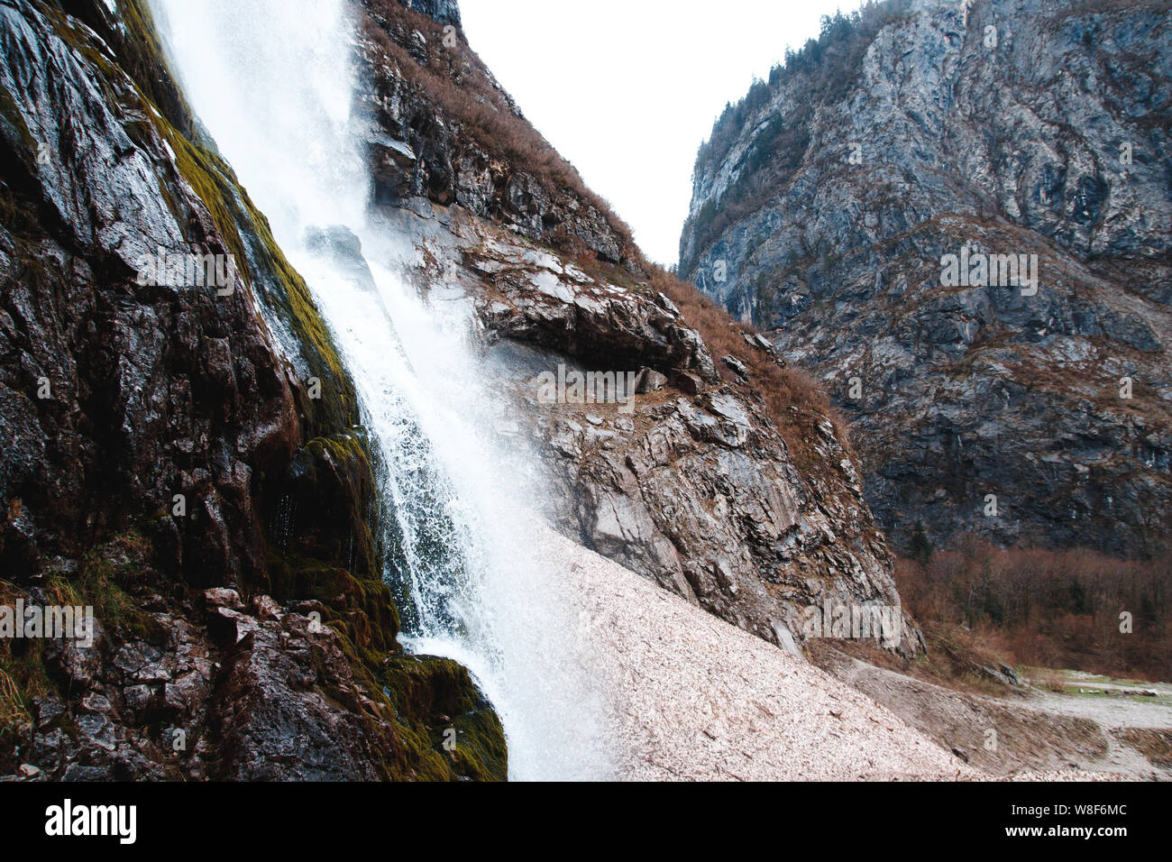 Small cliffy mountain spring waterfall in Abkhazia. Craggy ridge cliff ...