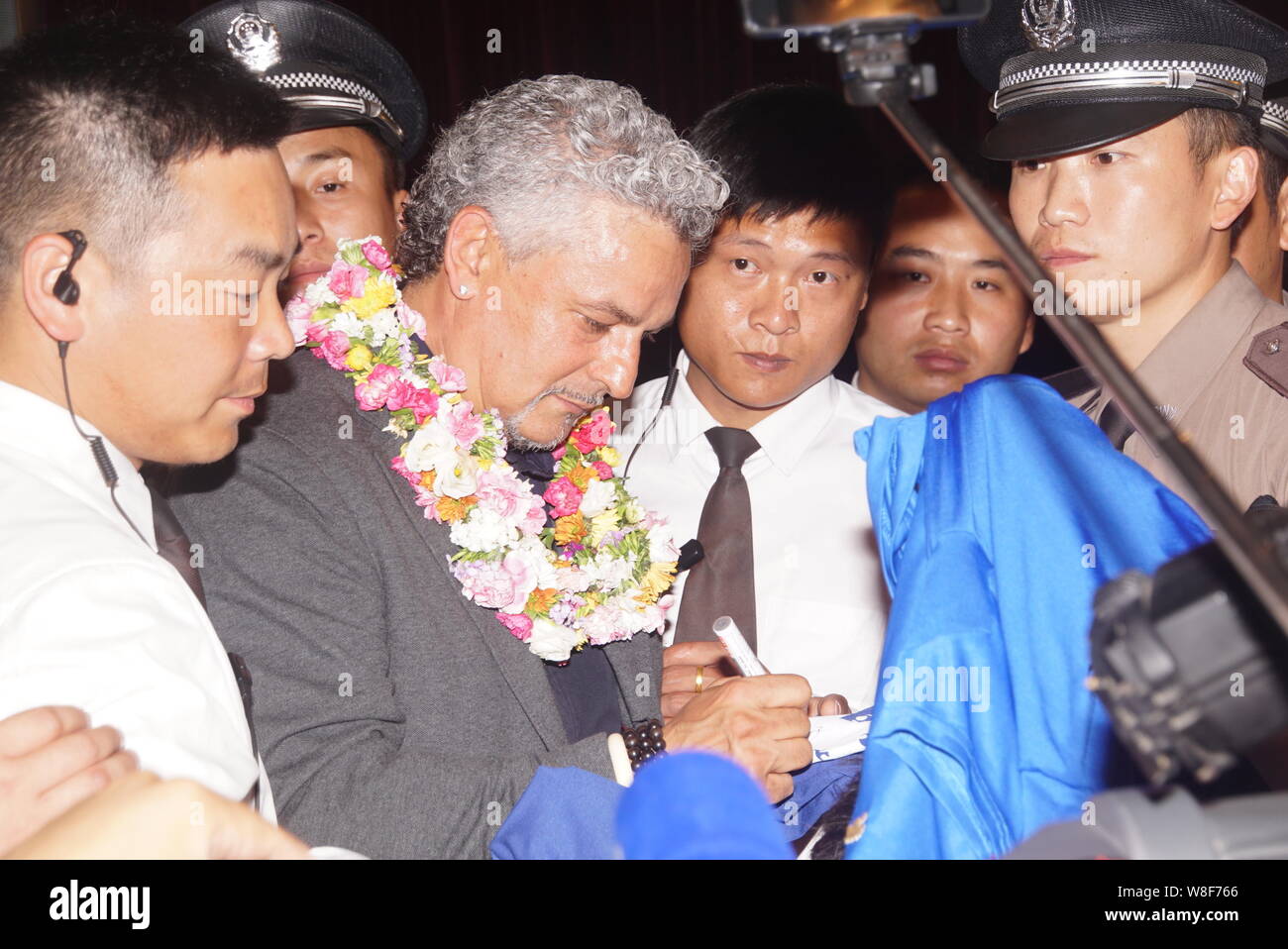 Retired Italian football star Roberto Baggio, center, signs for fans ...