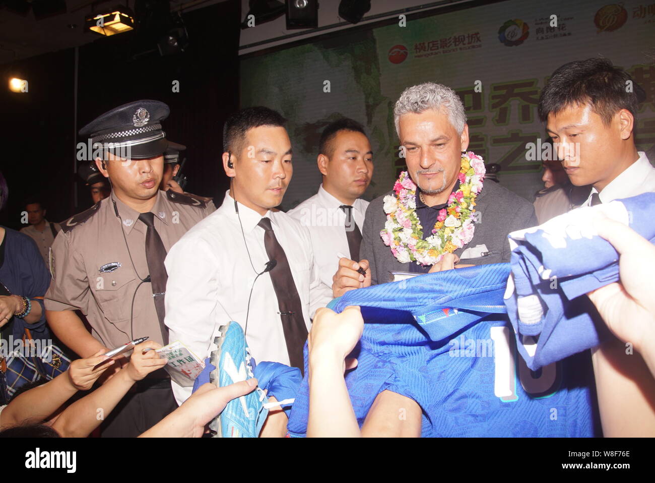 Retired Italian football star Roberto Baggio, center, signs for fans ...