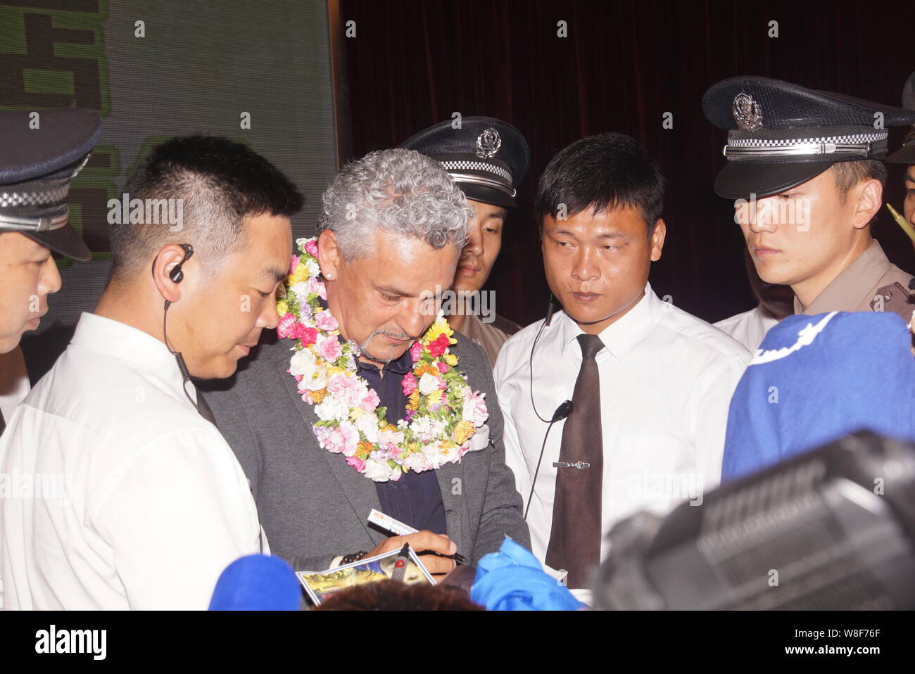 Retired Italian football star Roberto Baggio, center, signs for fans ...
