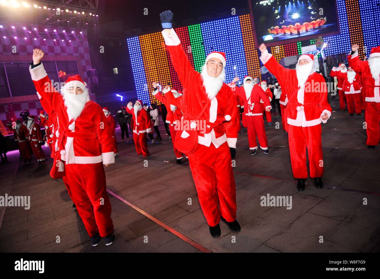 Entertainers dressed in Santa Claus costumes perform in a flash mob to ...