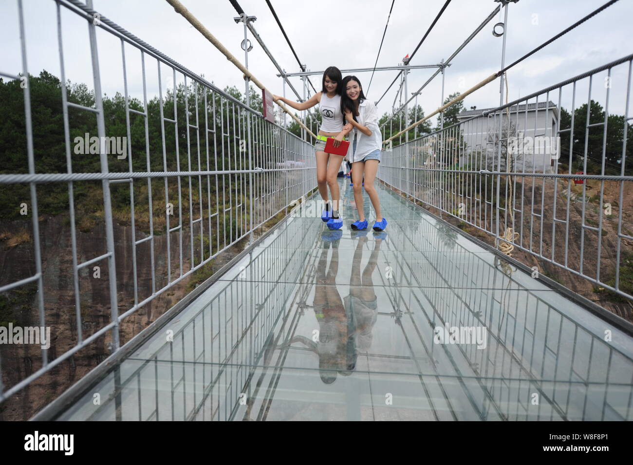 Visitors walk on the 180-meter-high and 300 meter-long glass-bottomed ...