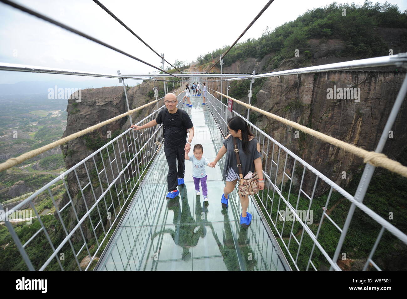 Visitors walk on the 180-meter-high and 300 meter-long glass-bottomed ...