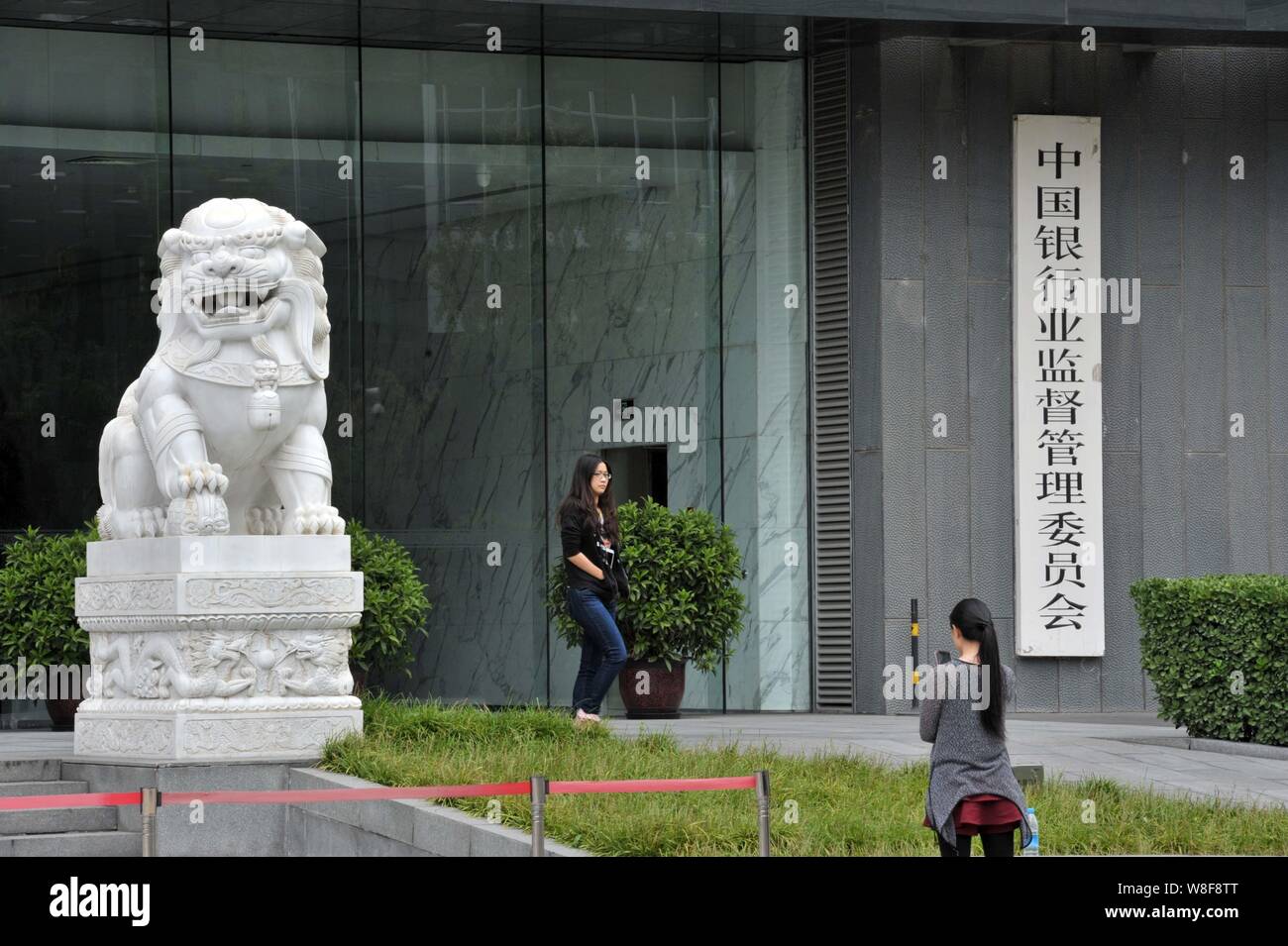 --FILE--Pedestrians walk past the headquarters of the CBRC (China ...