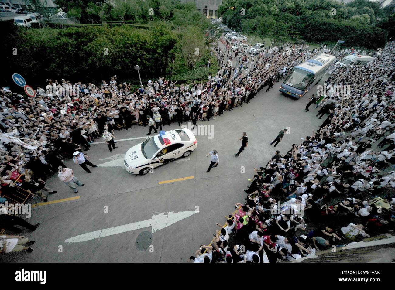 A crowd of football fans watch the arrival of a bus carrying players of ...