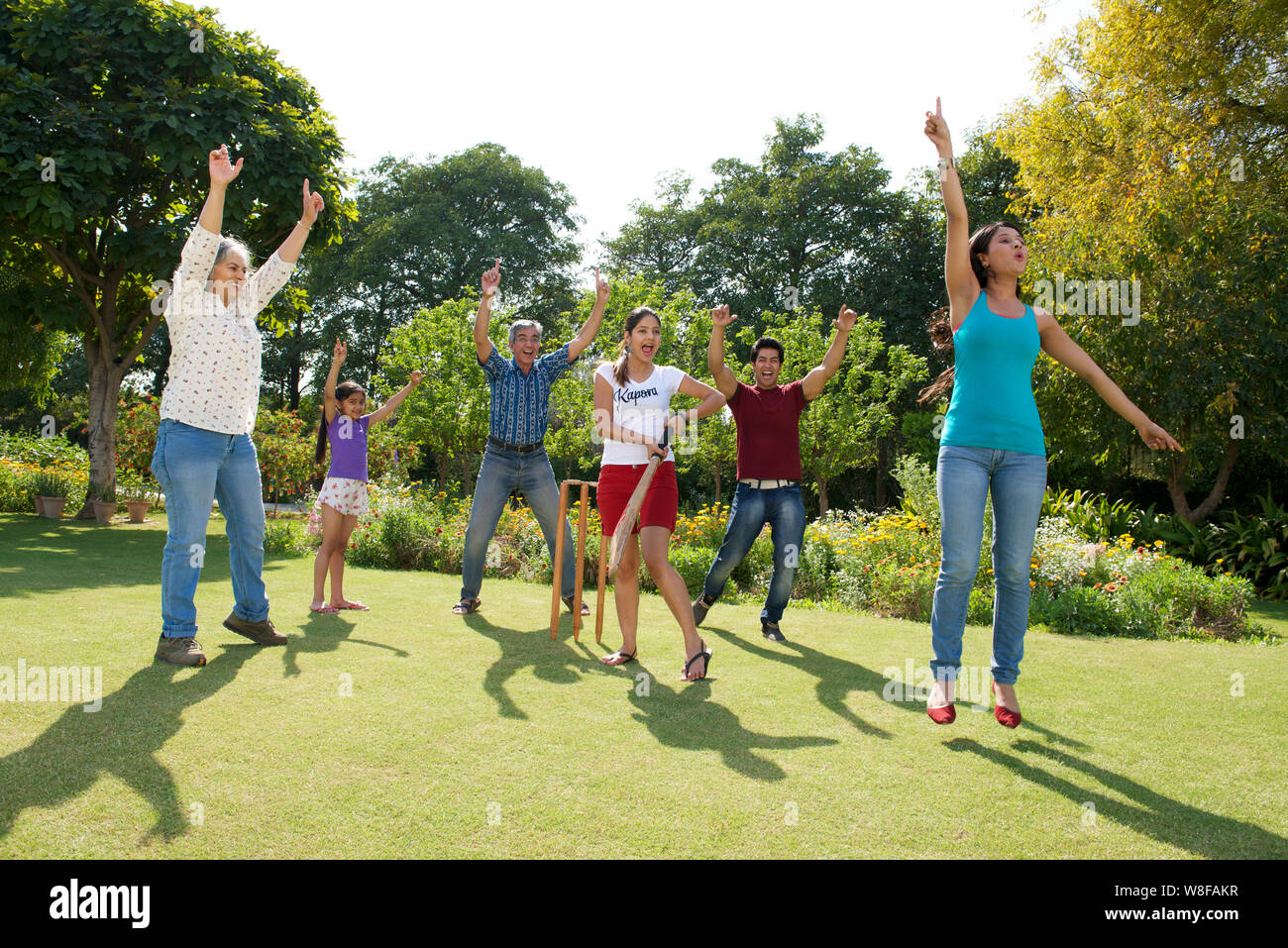Family playing cricket in lawn Stock Photo - Alamy