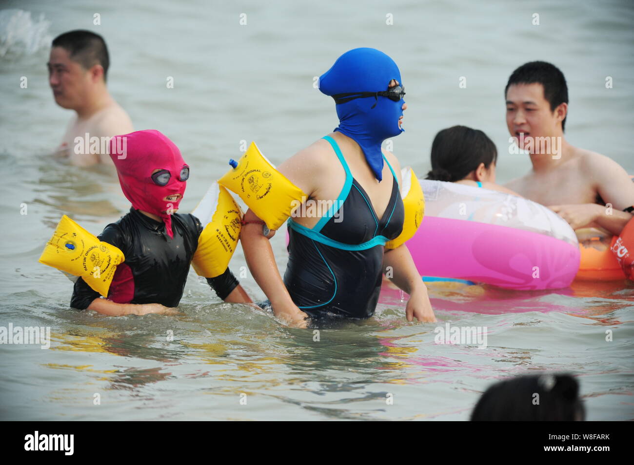Female Chinese swimmers wearing facekinis have fun in the water at a ...