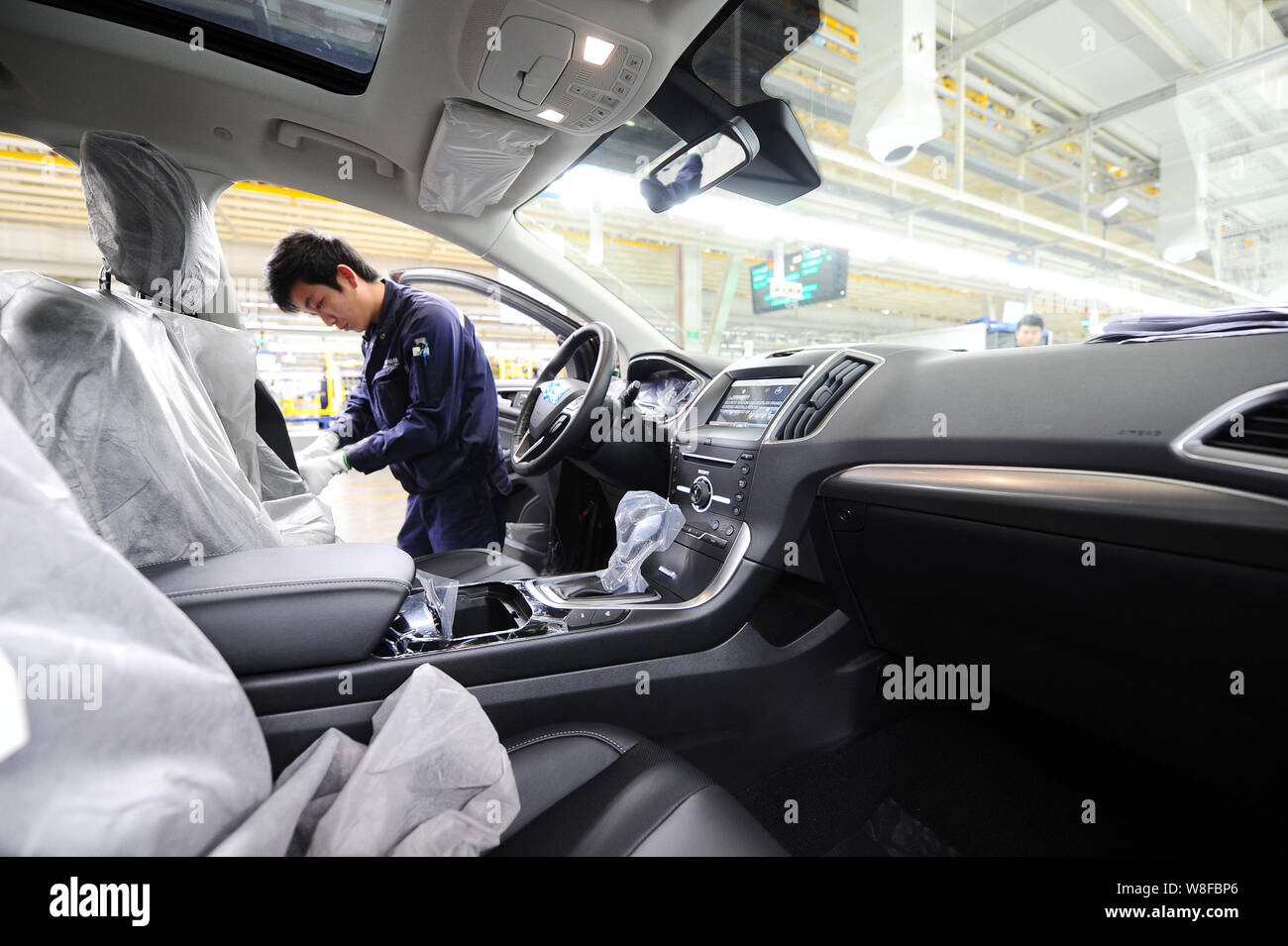 A Chinese worker assembles a Ford SUV on the assembly line at the auto ...