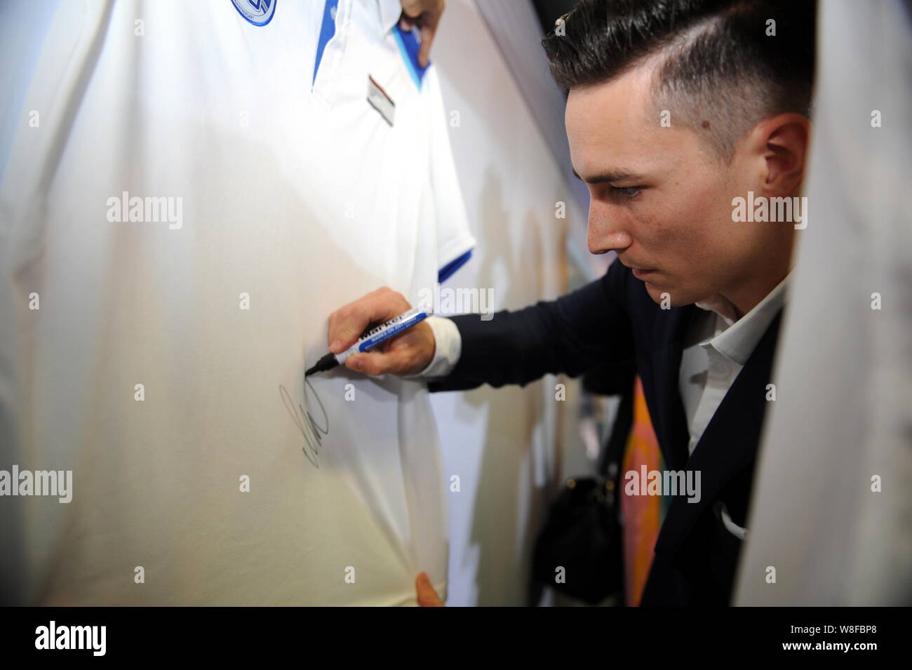 German gymnast Marcel Nguyen signs an autograph on a T-shirt during a ...