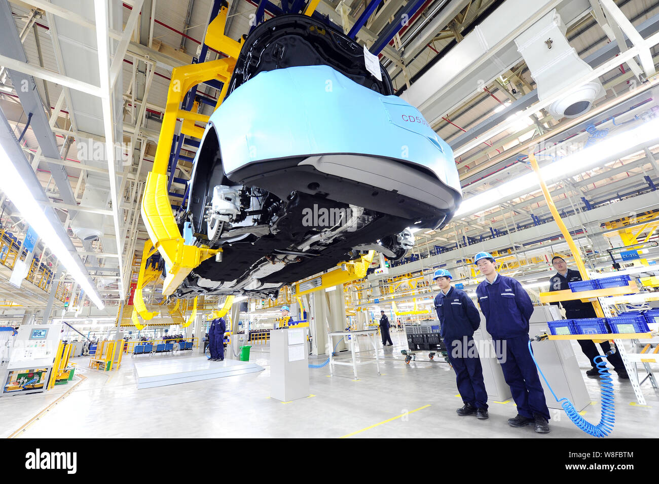 Chinese workers stand next to a Ford SUV on the assembly line at the ...