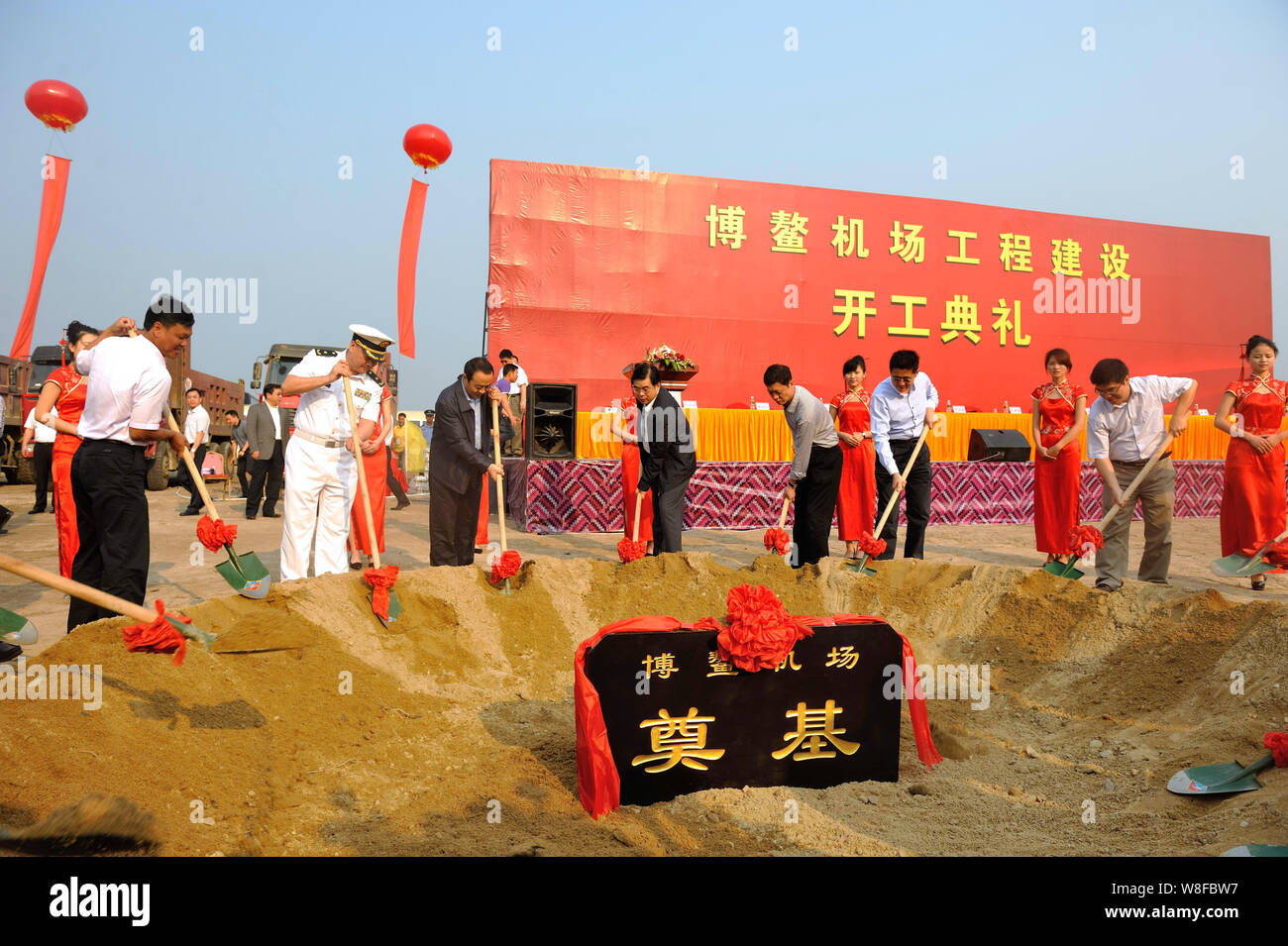 Chinese officials shovel sand to bury a foundation stone at the ...