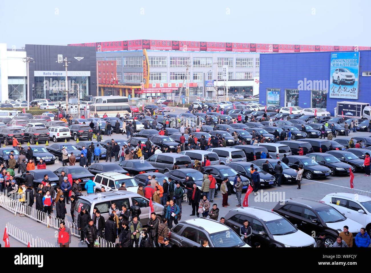 --FILE--Chinese car buyers look at government cars to be auctioned at a ...