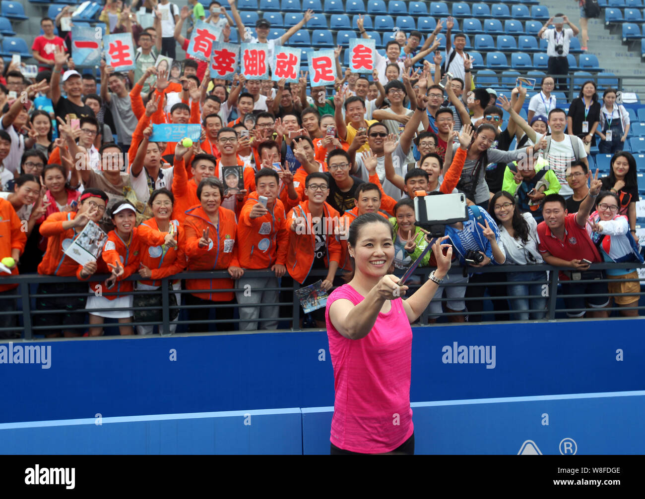 Retired Chinese tennis star Li Na, front, takes a selfie with fans in a ...