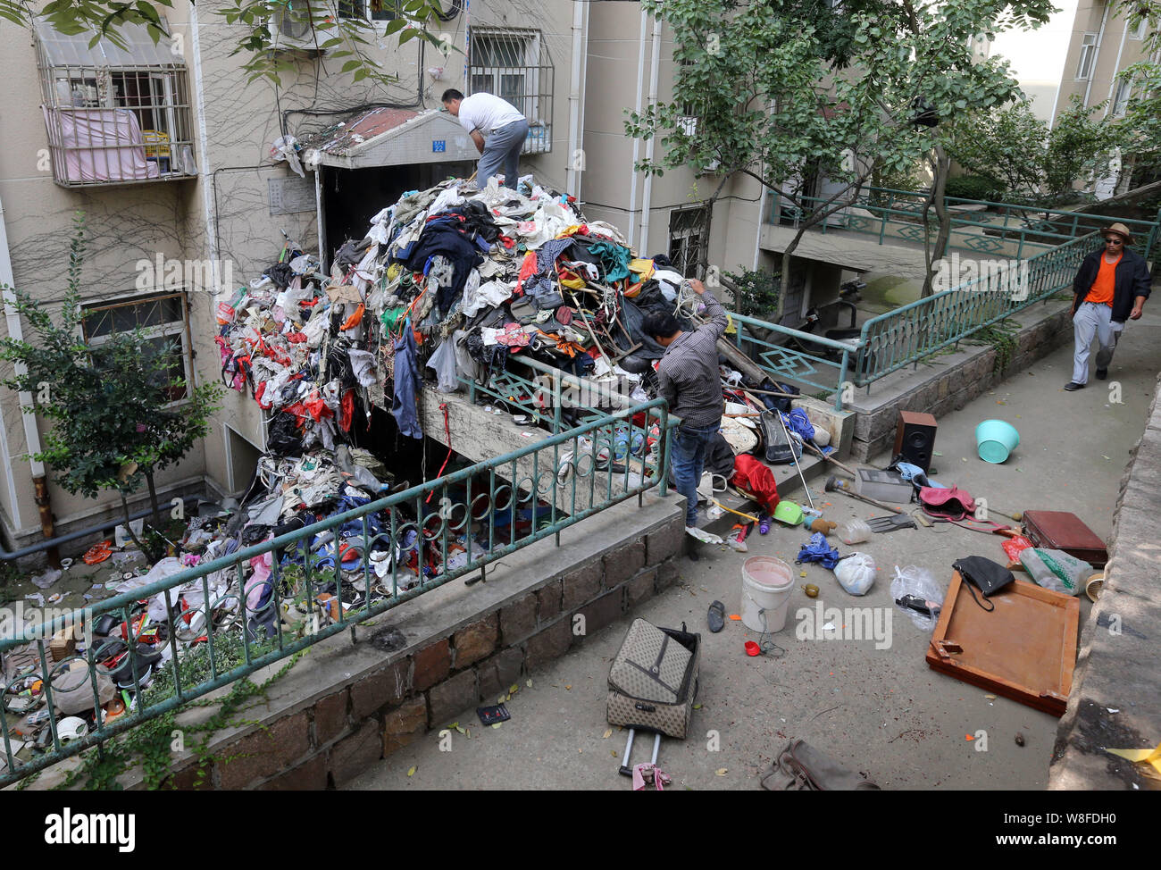 Chinese sanitation workers clear up a heap of trash accumulated by an ...