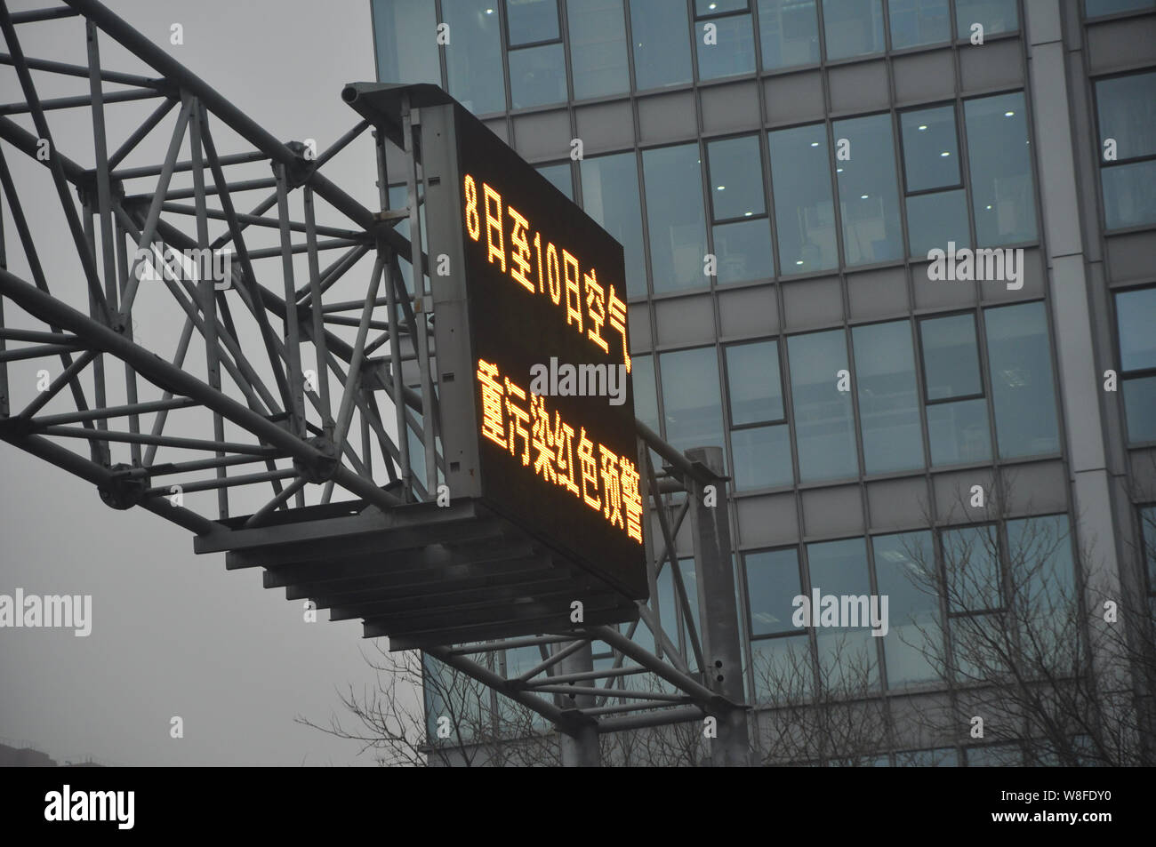 View of a board showing red alert for air pollution on a road in heavy ...
